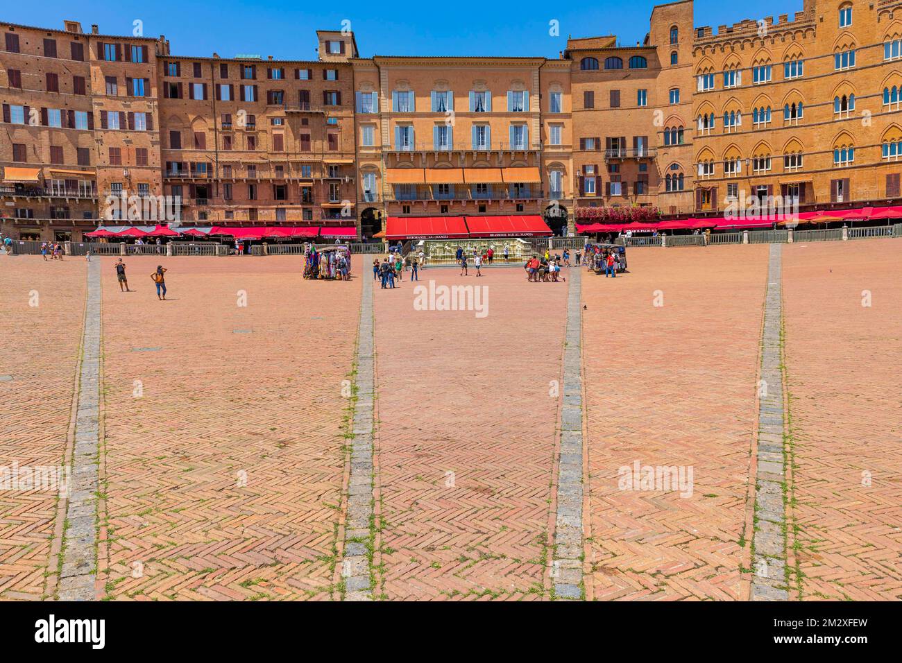 Brick pavement at the Piazza del Campo, behind medieval palaces with ...