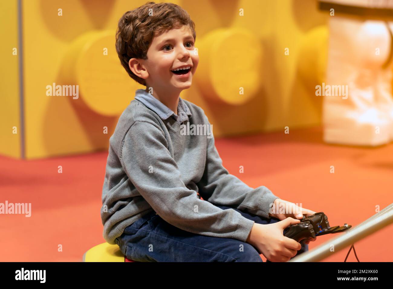 Adorable little caucasian boy playing video game holding controller ...