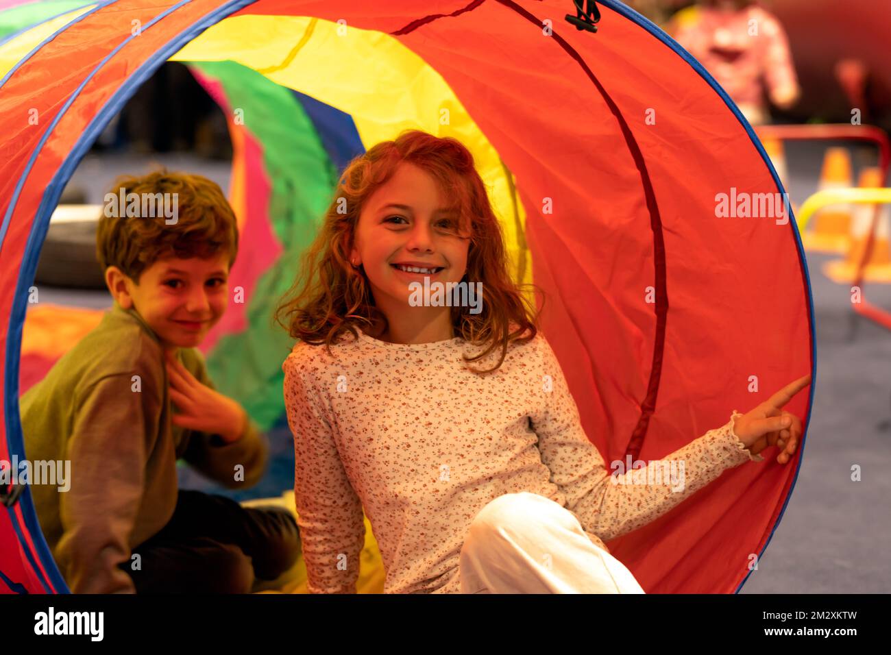 Upbeat siblings in casual clothes smiling and looking at camera while ...