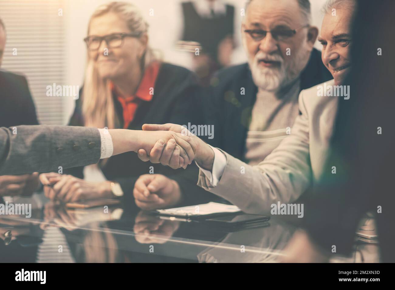 Mature entrepreneurs shaking hands during business negotiations ...