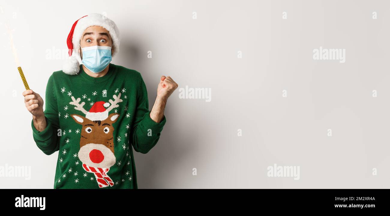 Concept of covid-19 and Christmas holidays. Happy young man in face ...