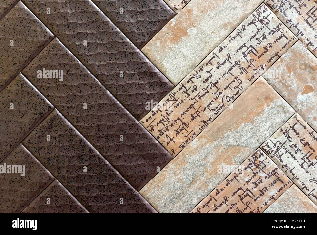 Brown and beige ceramic tiles with letters laid out in a herringbone ...