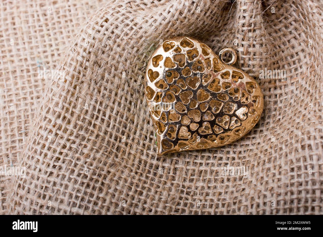 Heart shaped gold color metal object on canvas Stock Photo - Alamy