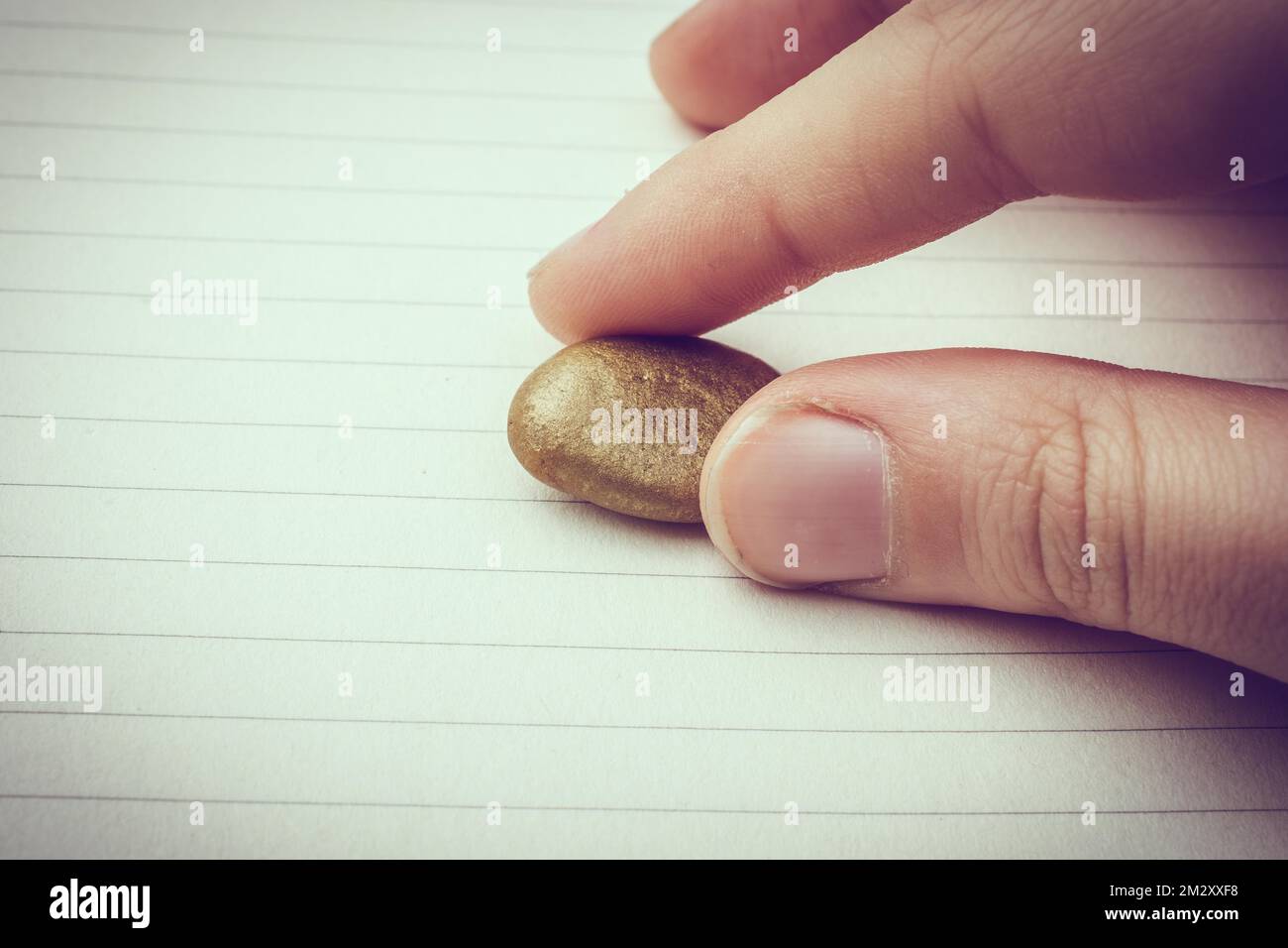 Little gold color pebble in the hand Stock Photo - Alamy