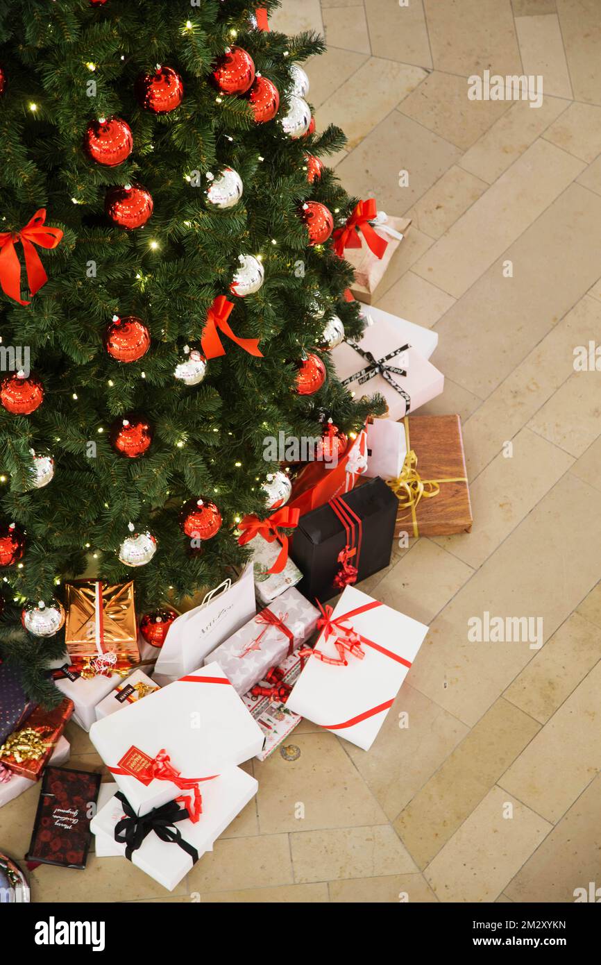 Christmas shopping, a Christmas tree, in a mall. People shopping for ...