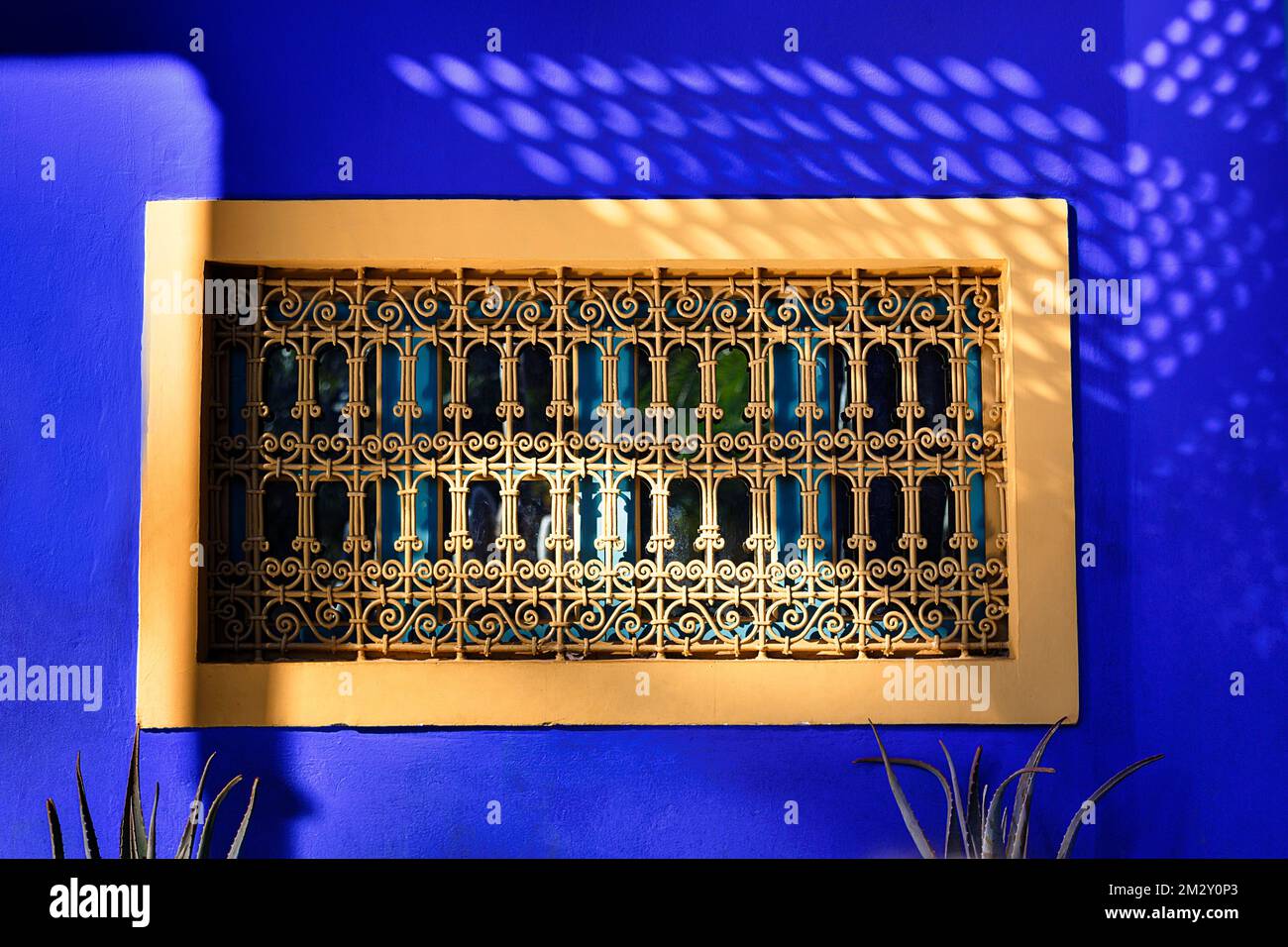 Ornate window grille in a blue wall, arabesque, Jardin Majorelle ...
