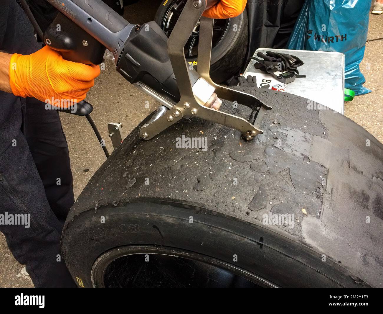 Race mechanic cleans surface of racing tyres slicks makes ...