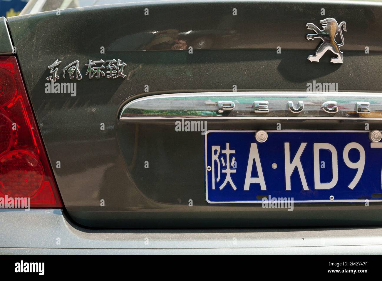 Older Peugeot car rear with numberplate and model written in Chinese ...