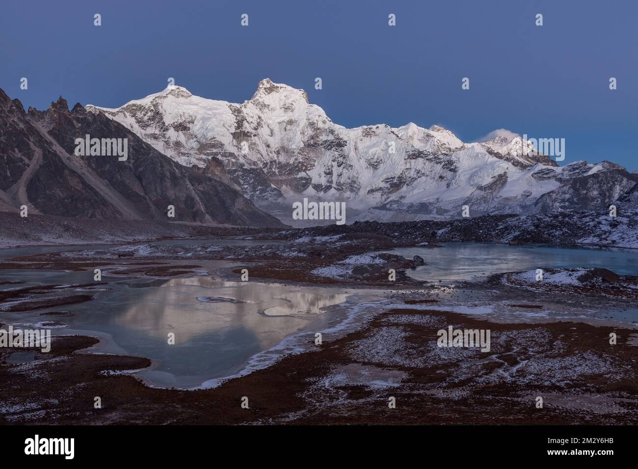 Snowy range of Cholatse mountain reflecting in moraine lakes ...