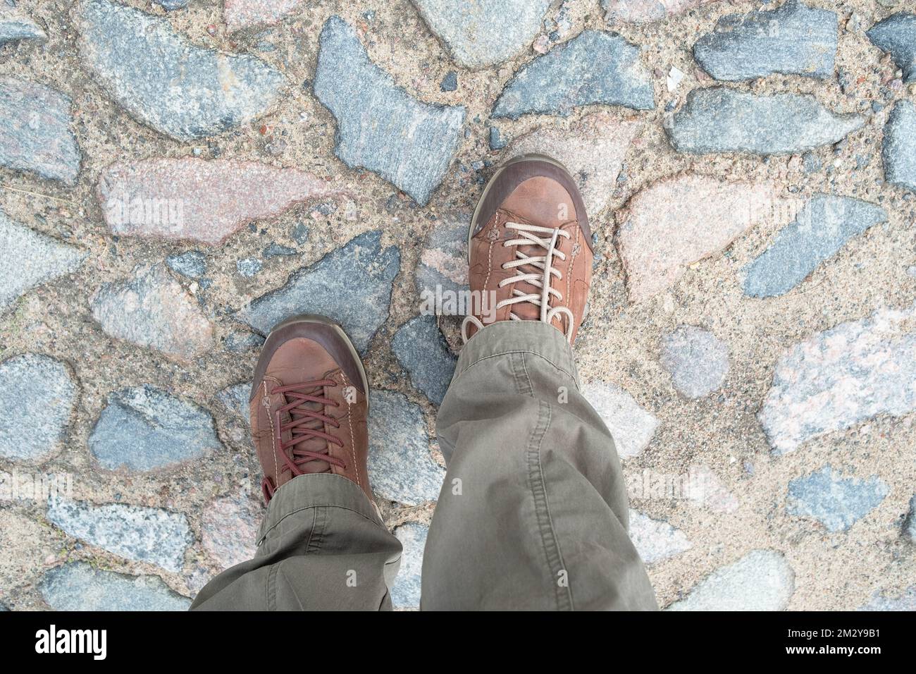 Feet in comfortable trekking shoes, suitable for long walks, stand on ...