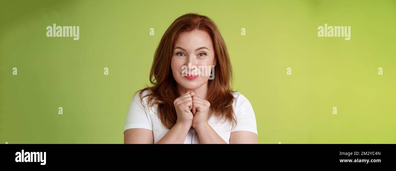 Cheerful lovely pleasant redhead middle-aged female press hands ...