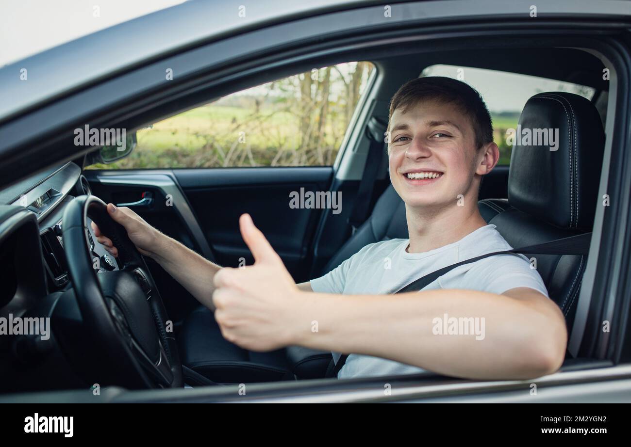 Happy and proud guy shows thumb up gesture. Confident driver with ...