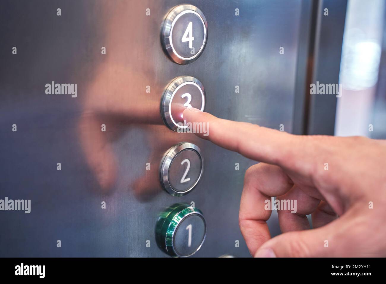 Man hand pointing number 3 button in elevator. Steel interior panel ...