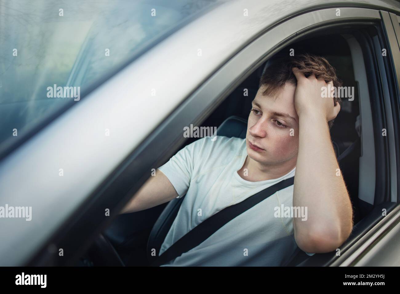 Unlucky and fatigue driver stuck in a traffic jam, looking upset out of ...