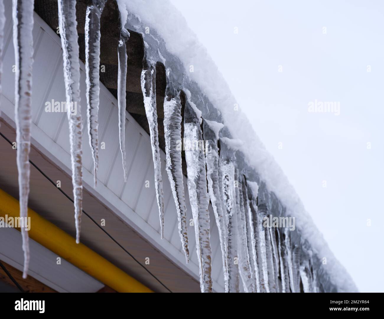 Hanging icicles off roof hi-res stock photography and images - Alamy