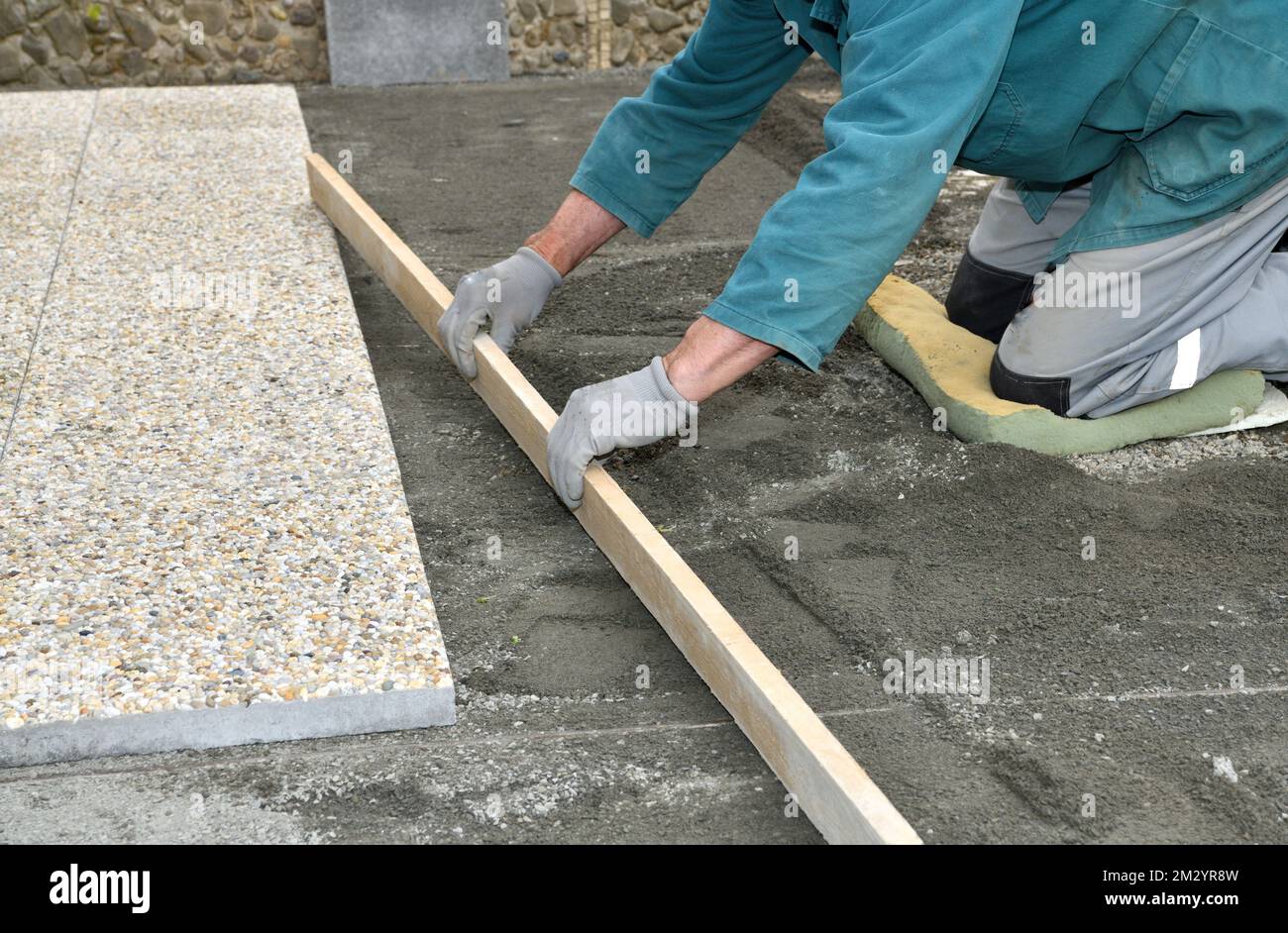 The bricklayer levels the floor using a spirit level and sand before ...