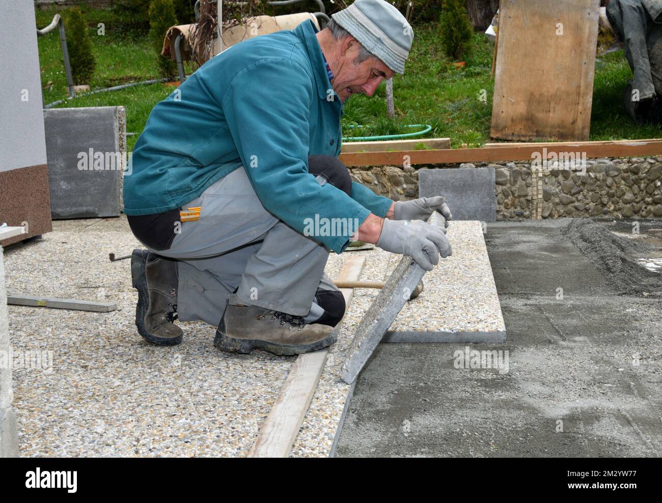 The bricklayer levels the floor using a spirit level and sand before ...