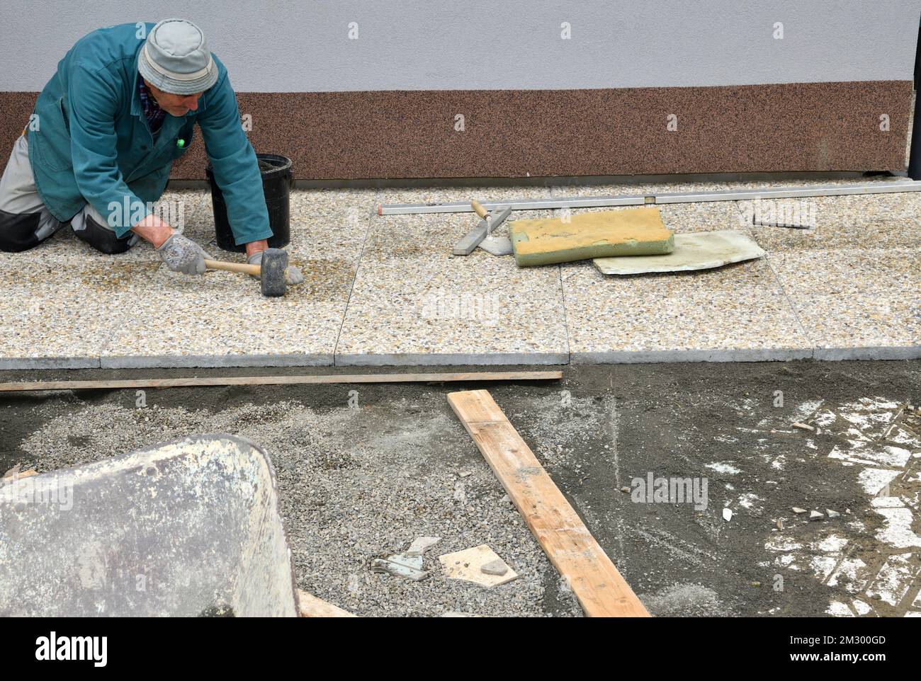 Construction of concrete paving stone around the house manually Stock ...