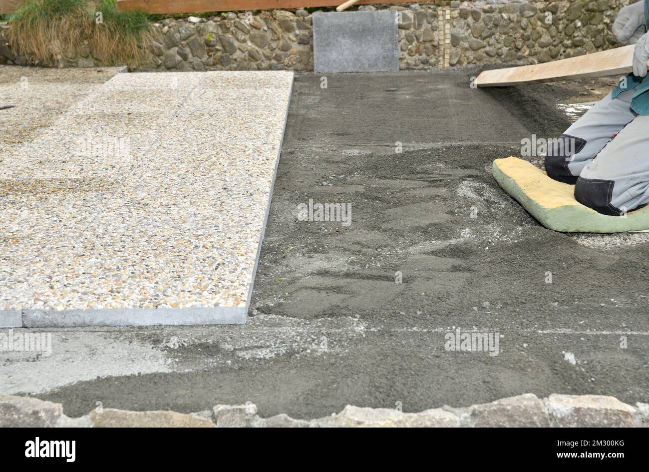 Construction of concrete paving stone around the house manually Stock ...