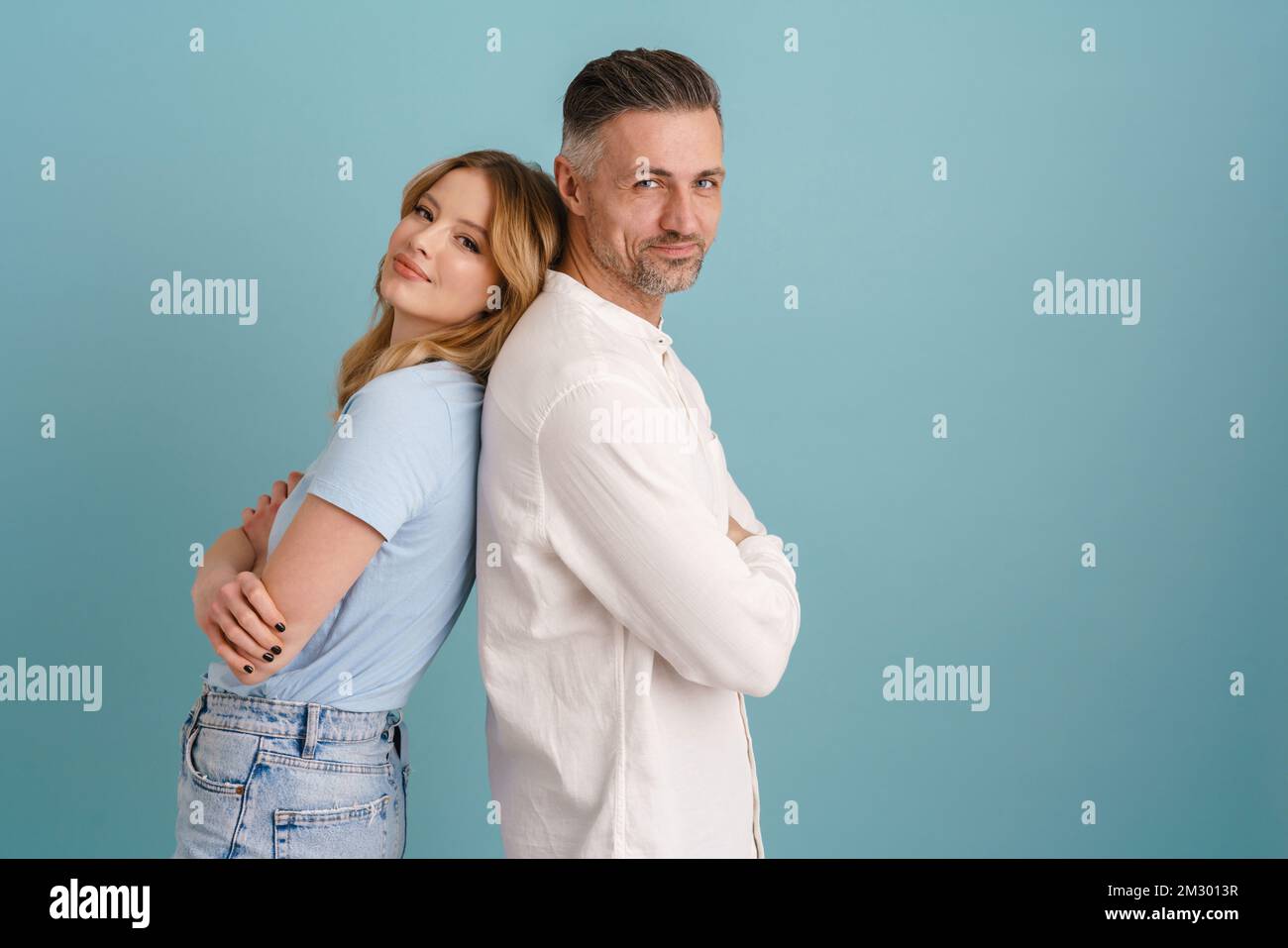 White happy man and woman smiling while standing back to back isolated ...