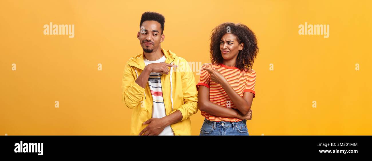 Two best friends fooling around having fun pointing at each other with ...