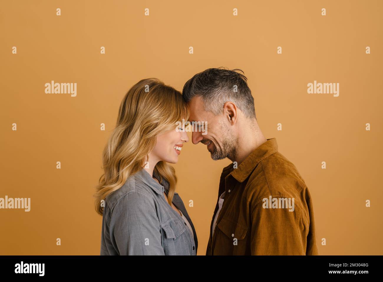 White happy couple smiling while posing head to head isolated over ...