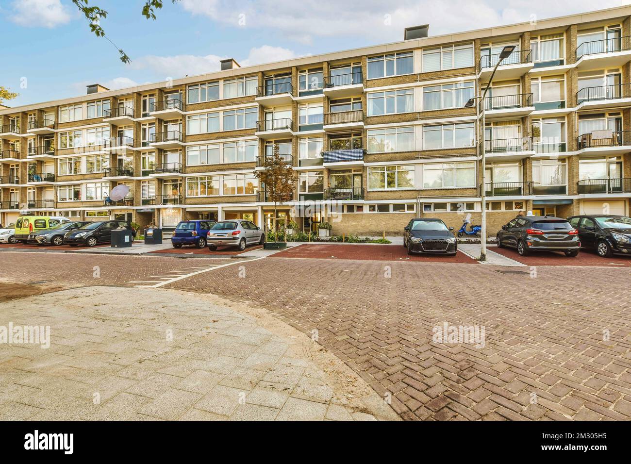 an apartment complex with cars parked on the street in front of thema's ...