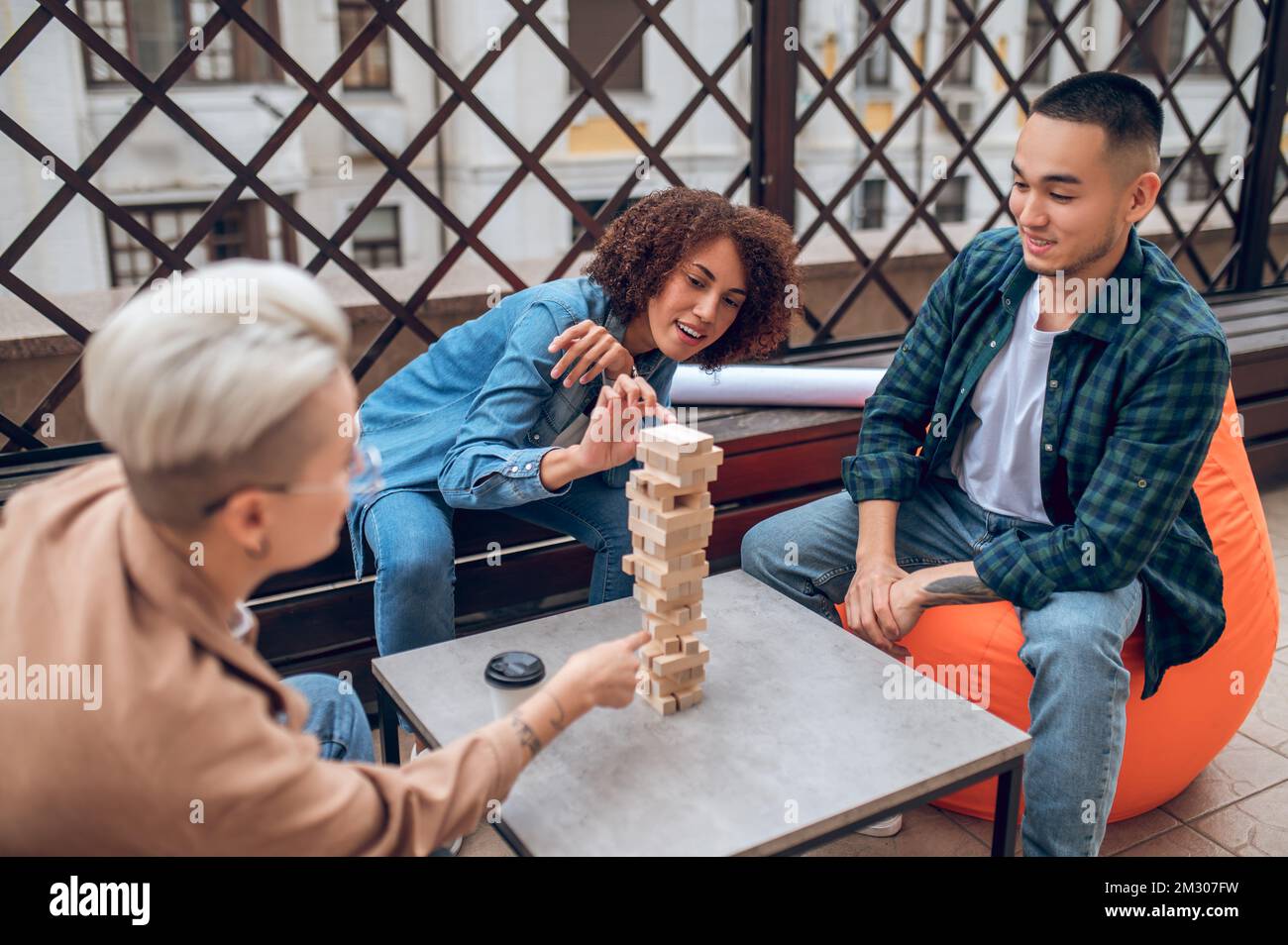 Three friends playing a board game on the veranda Stock Photo - Alamy