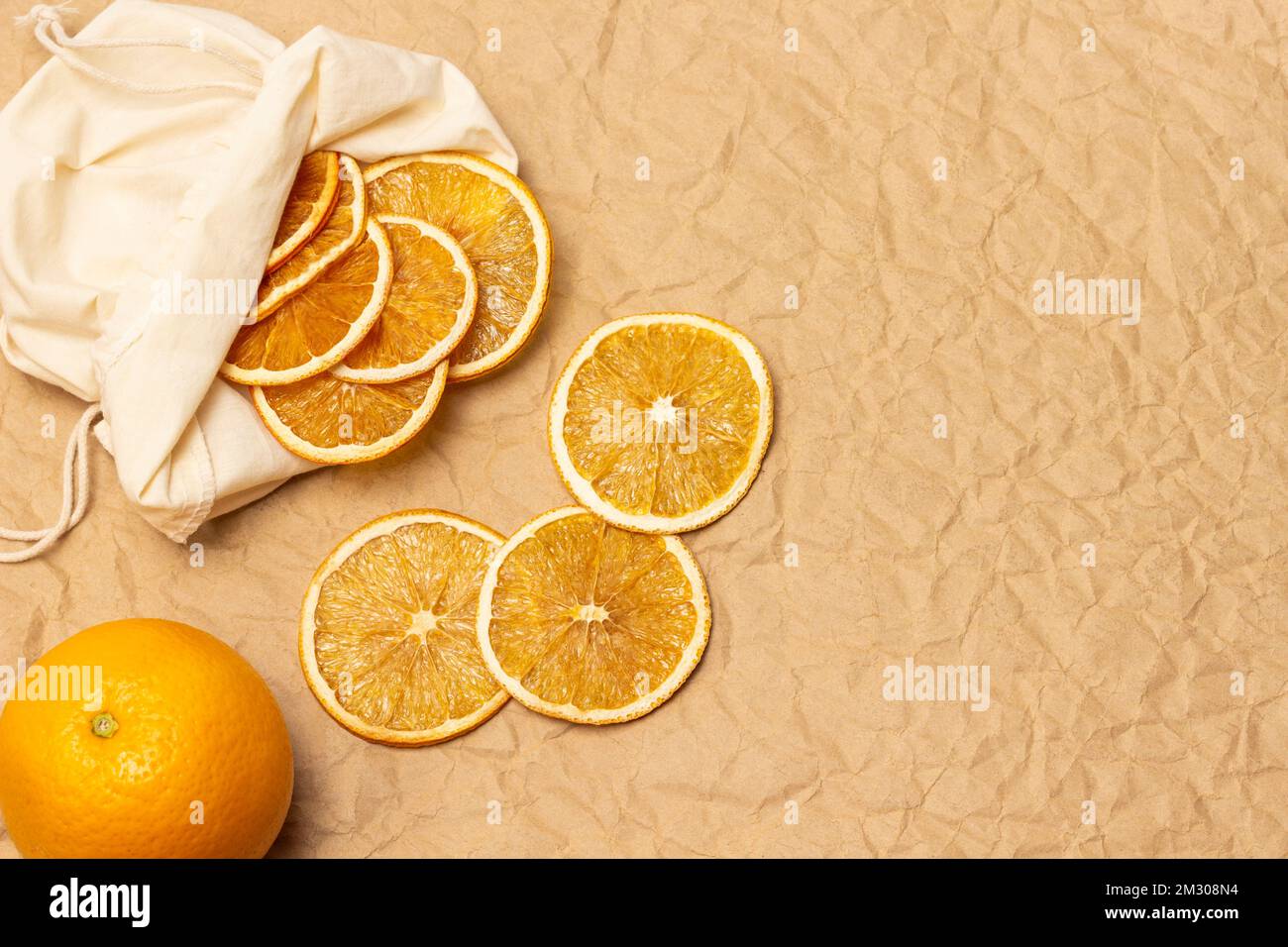 Slices of dried orange in a fabric bag. Fresh, whole orange. Copy space ...