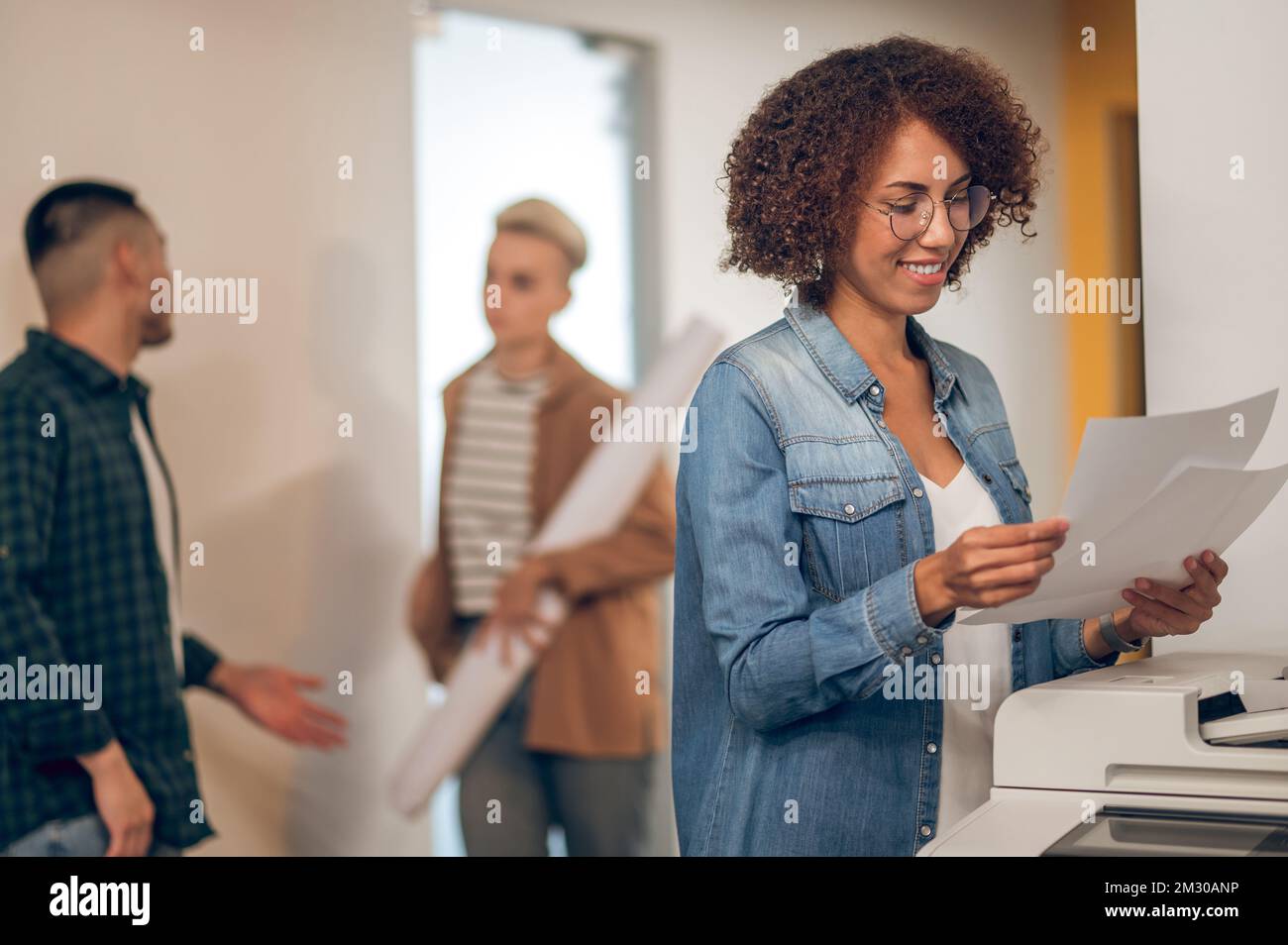 Joyous young office employee holding document copies Stock Photo - Alamy
