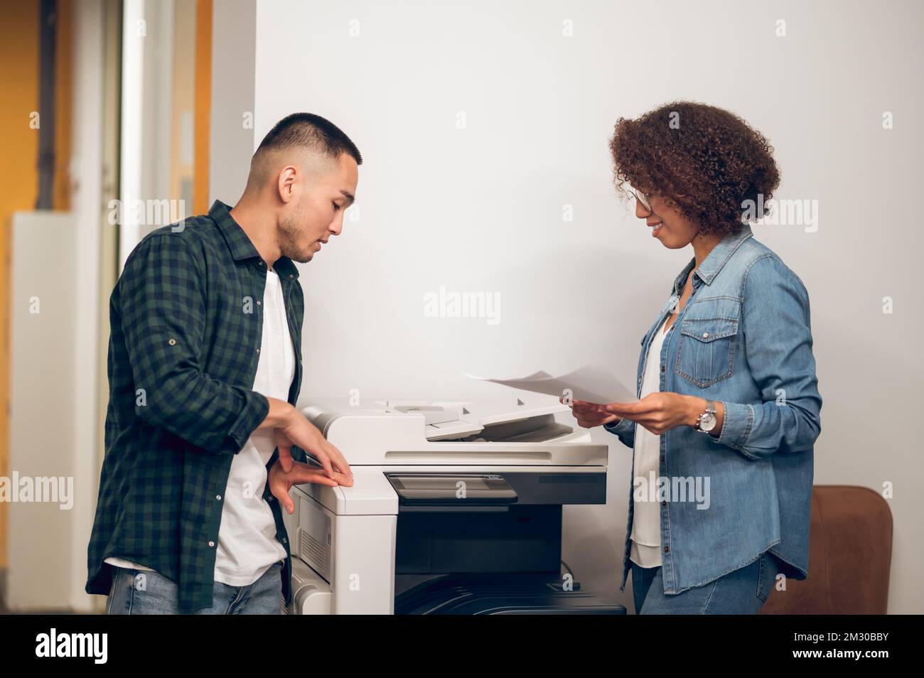 Assistant making document copies for her boss using the photocopier ...
