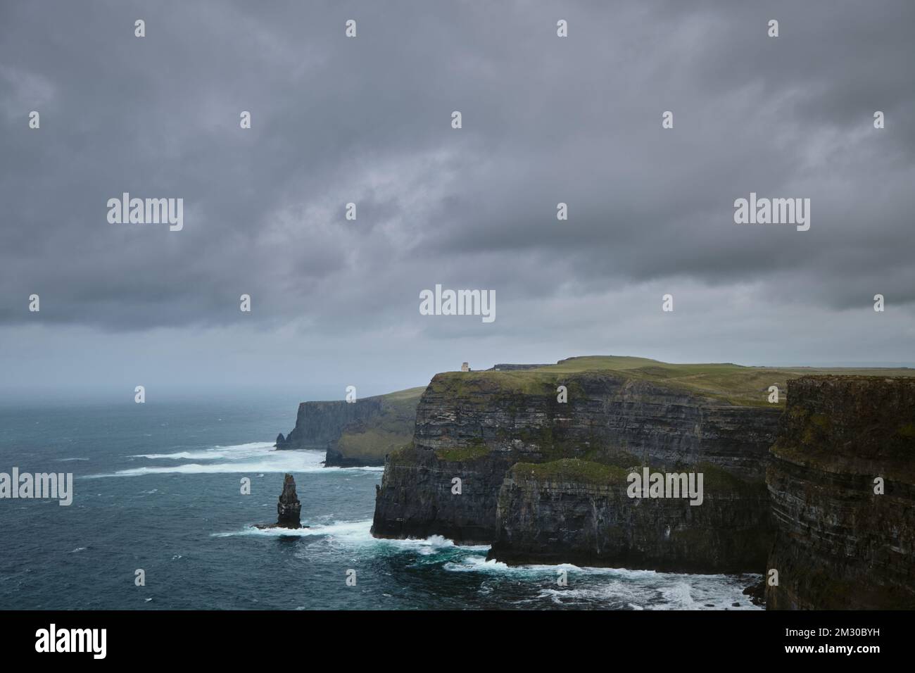 A scenic vertical view of the evergreen Cliffs of Moher in Ireland on a ...