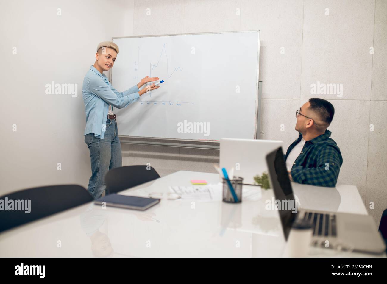 Company manager giving a business presentation to her colleague Stock ...