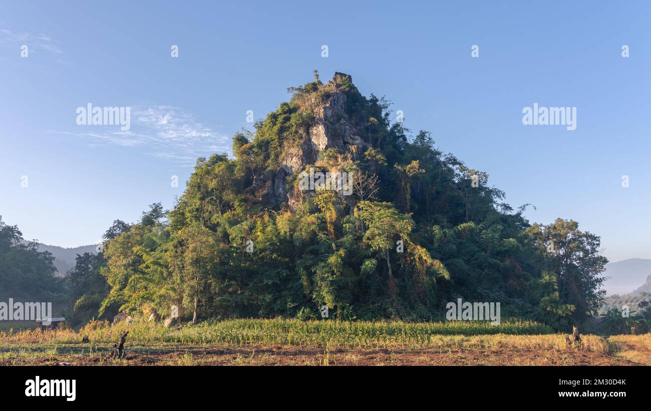Rural autumn landscape with isolated limestone hill in scenic mountain ...