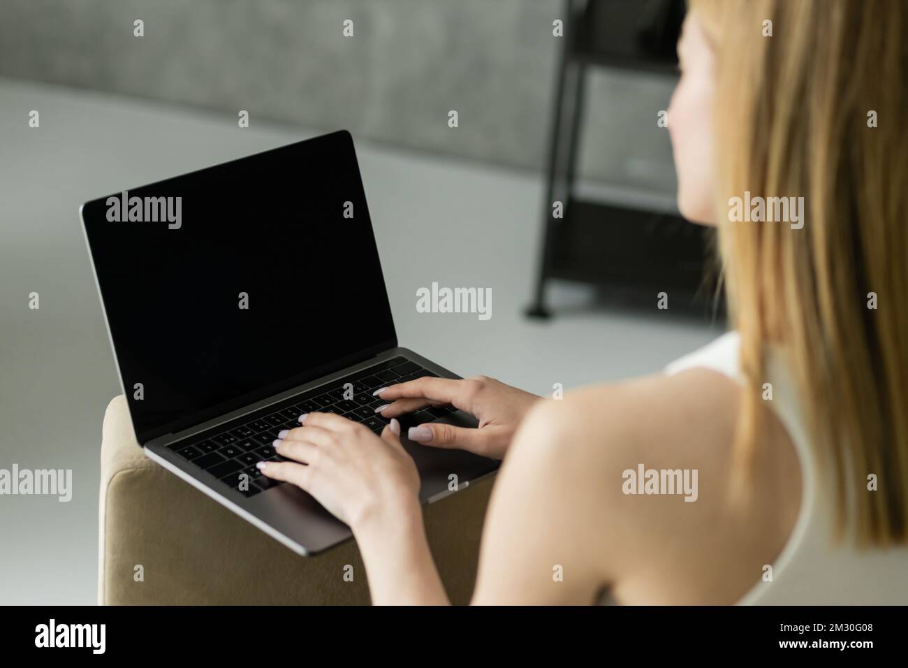 Blurred blonde freelancer using laptop with blank screen at home,stock ...