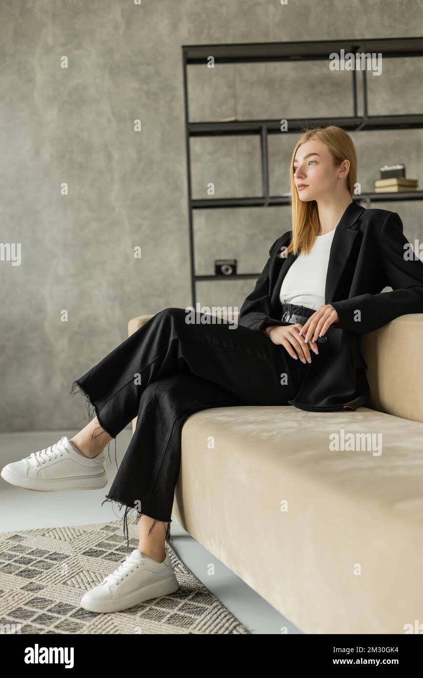 full length of stylish and pensive woman in black clothes and white ...