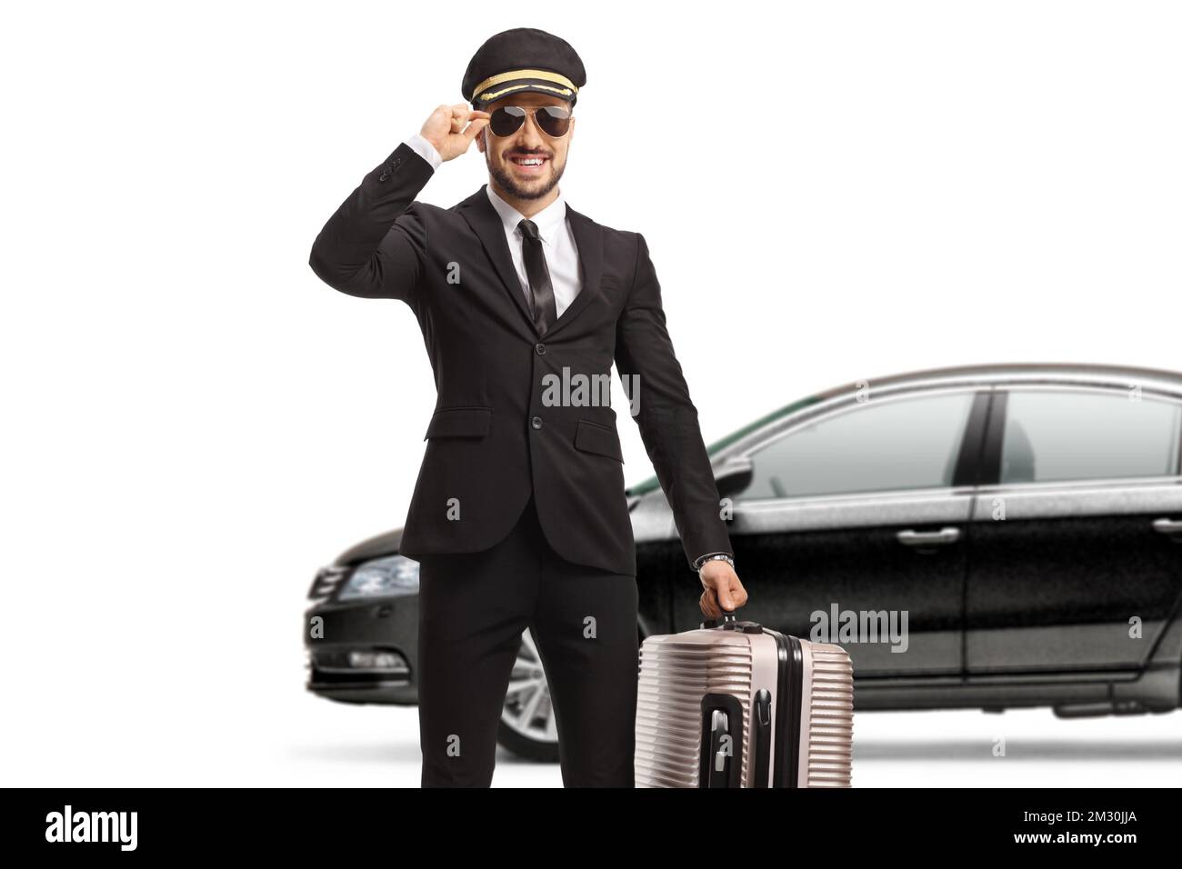 Chauffeur carrying a suitcase and greeting with his cap in front of a ...