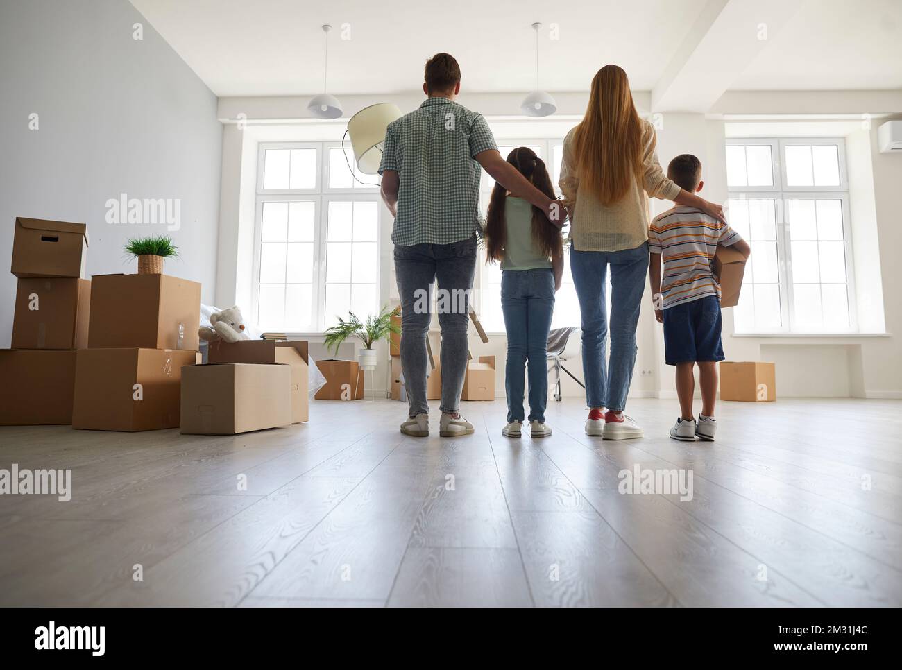 Happy family with children on moving day standing between cardboard ...