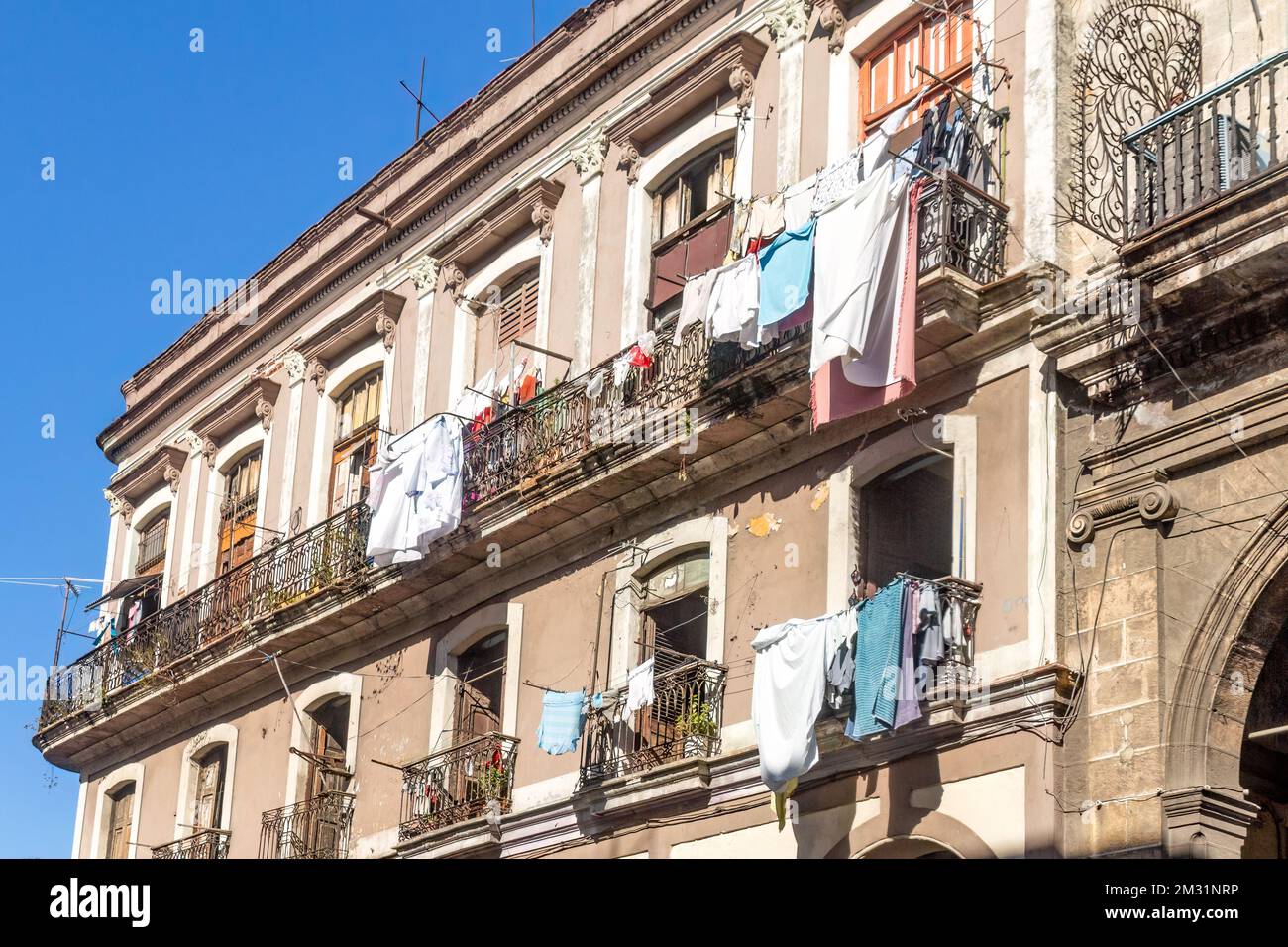 Clothes drying in the wind in the facade of a run-down apartment ...