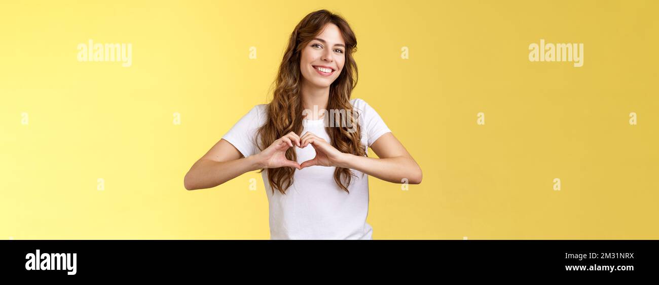 Carefree tender attractive woman curly long hairstyle show heart sign ...
