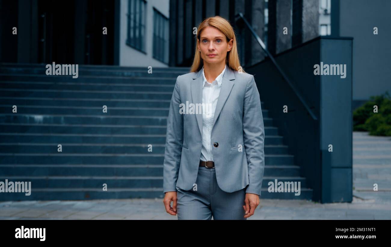 Confident successful Caucasian businesswoman in formal suit walking on ...