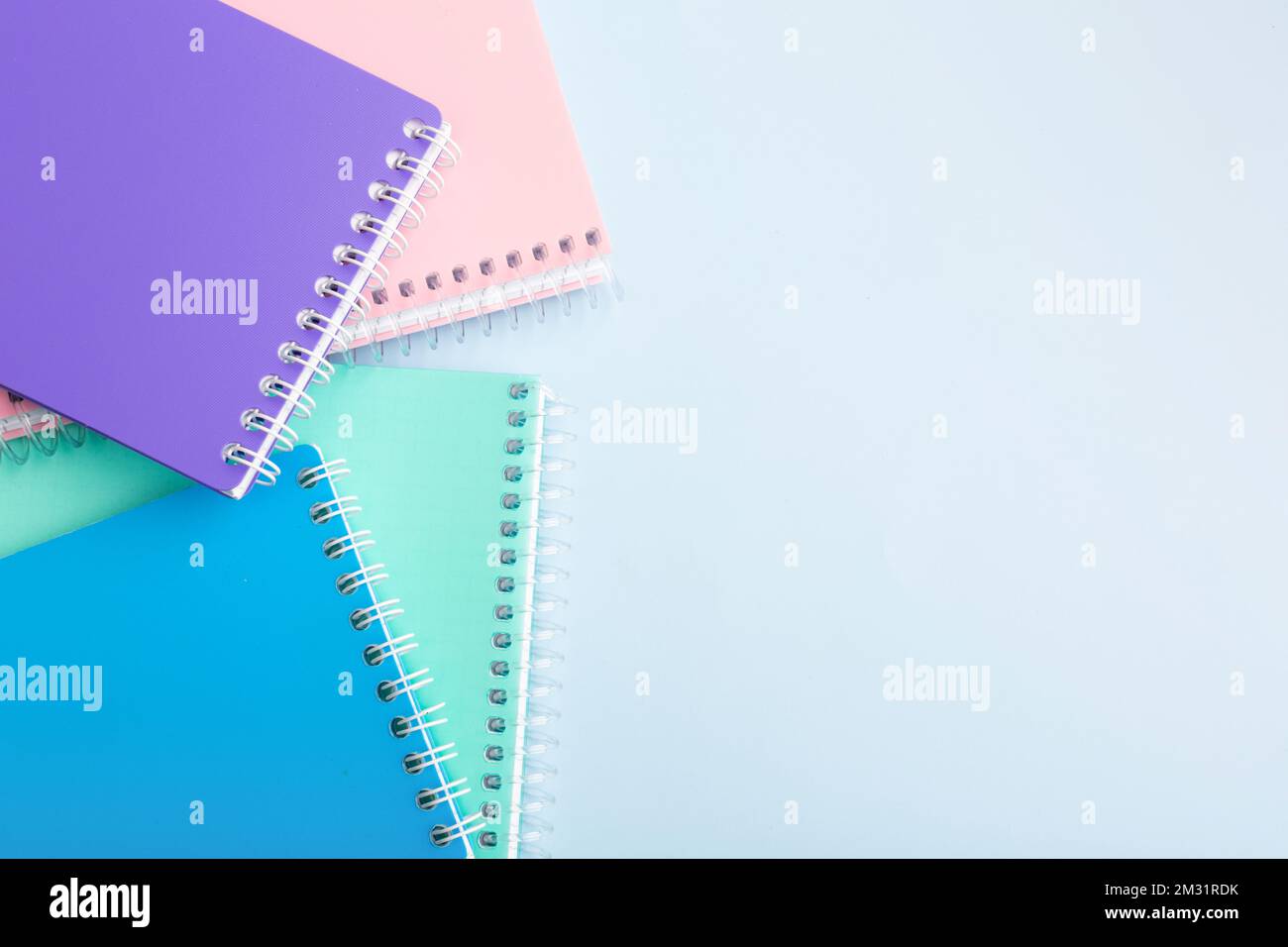 colored notebooks, colored pencils on a light table. Place for your ...