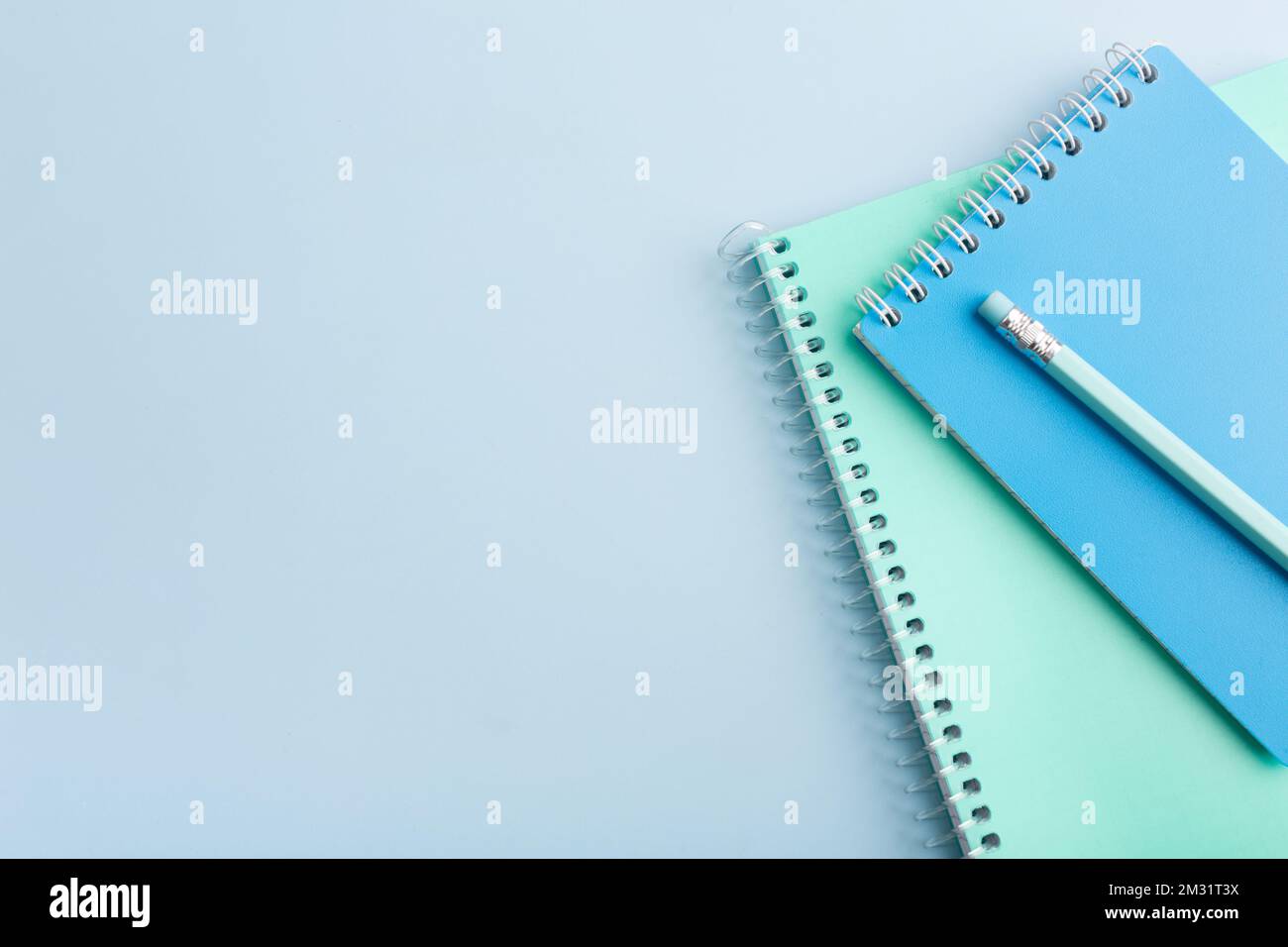 Blue notepad and pencil on a blue background. Place for your text. High ...