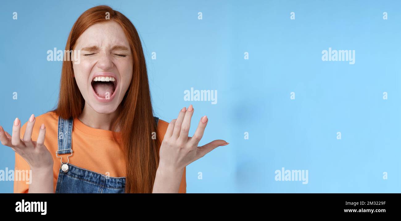 Pissed outraged moody redhead girl shouting complaining angry standing ...