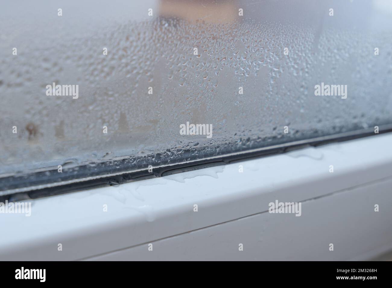 Water condensation on a window inside of a room during cold winter and ...
