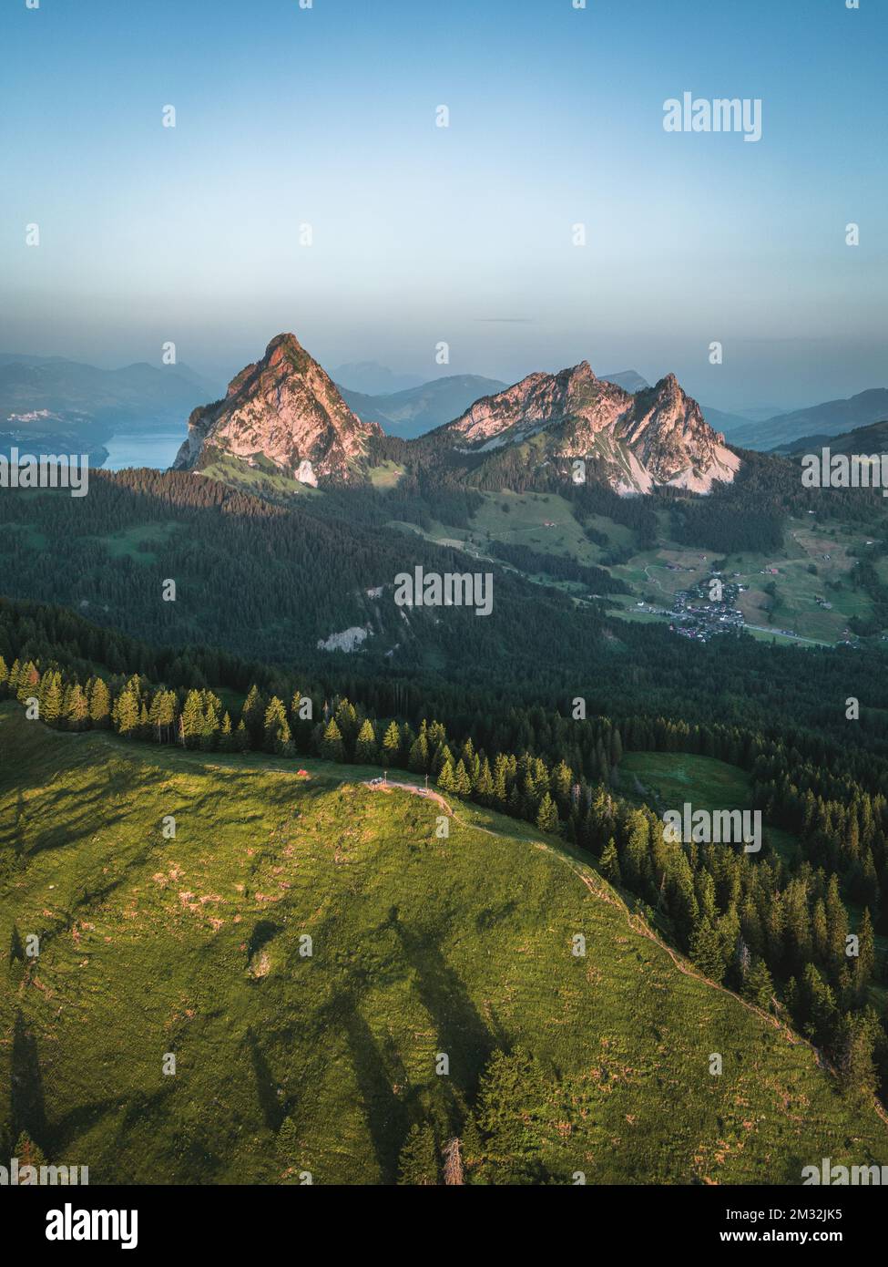 Vertical shot of beautiful small town in green valley on mountainside ...