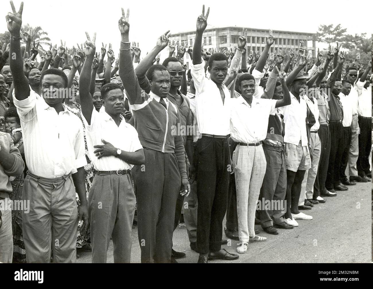 19600207 - LEOPOLDVILLE, CONGO: Men line the streets and raise their ...