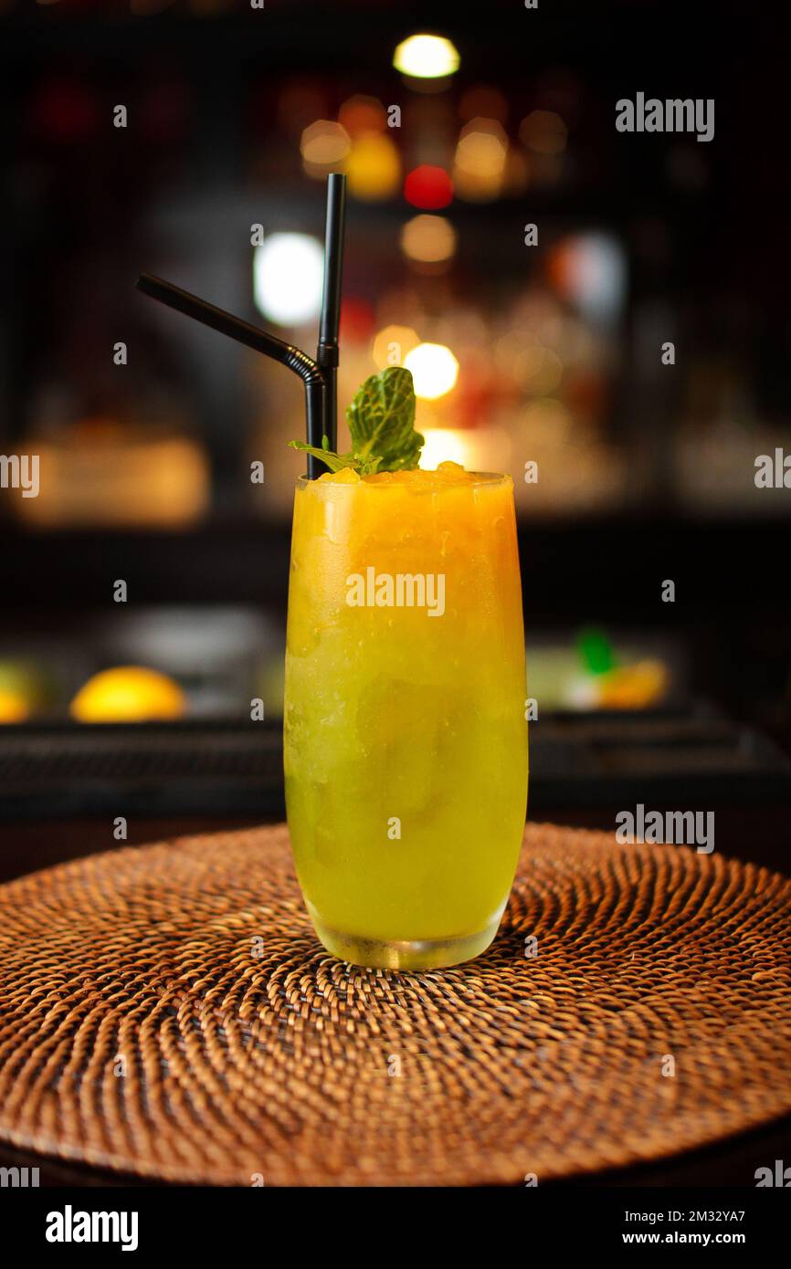 A vertical closeup of a delicious refreshing cocktail on a bar counter ...