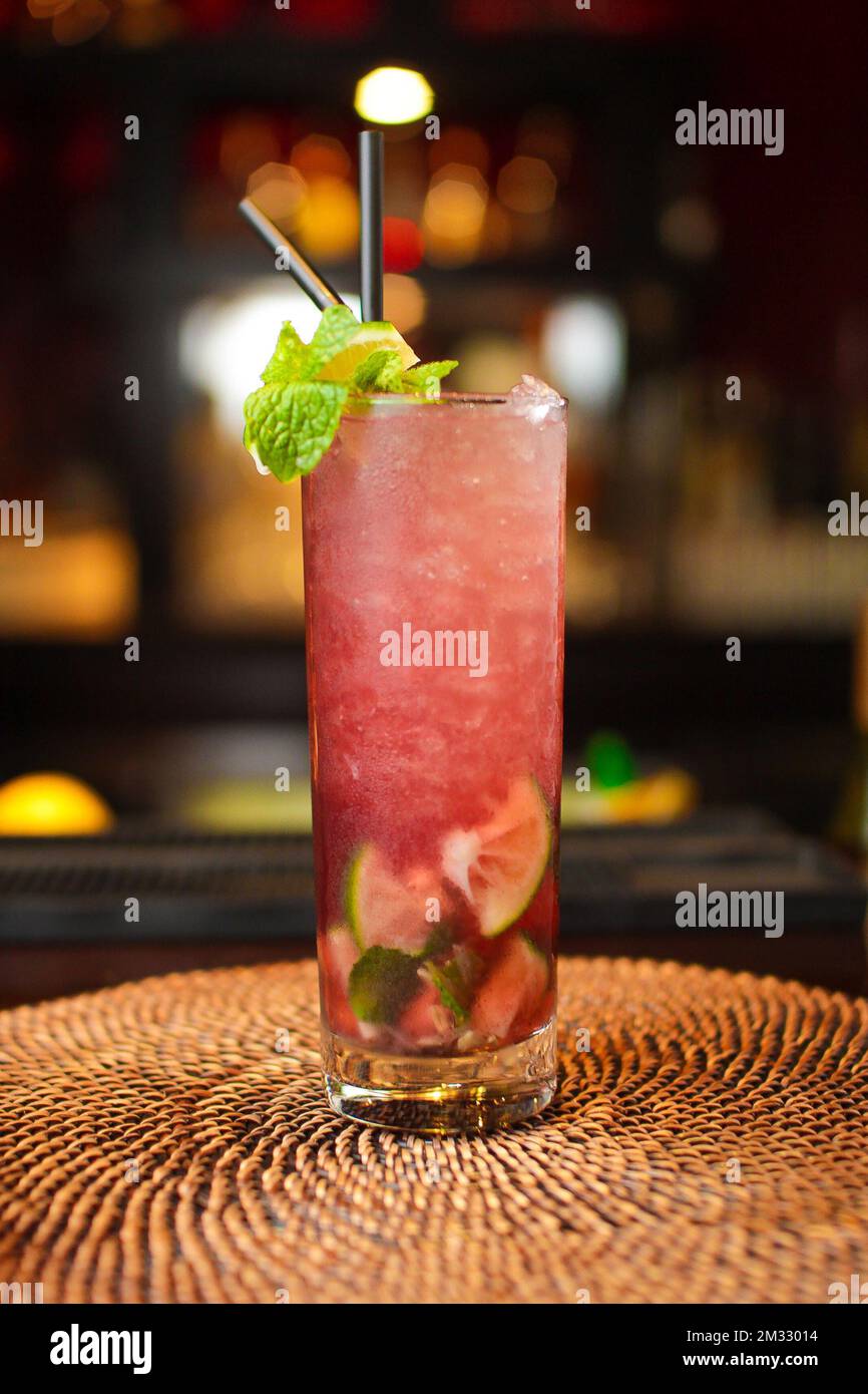 A vertical closeup of a refreshing citrusy cocktail on a bar counter ...