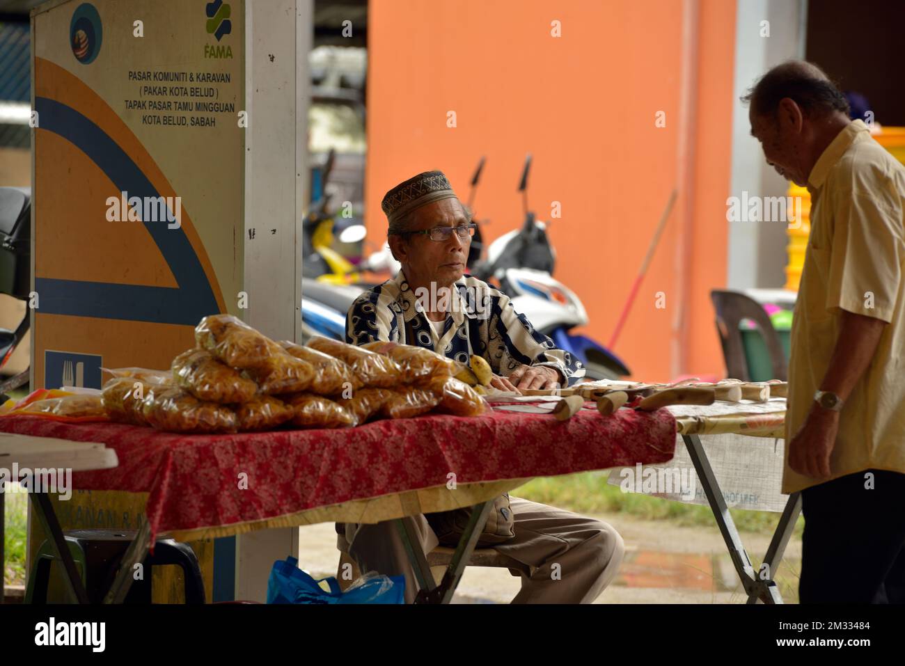 An indigenous Bajau man selling food at the Sunday market (tamu) in ...